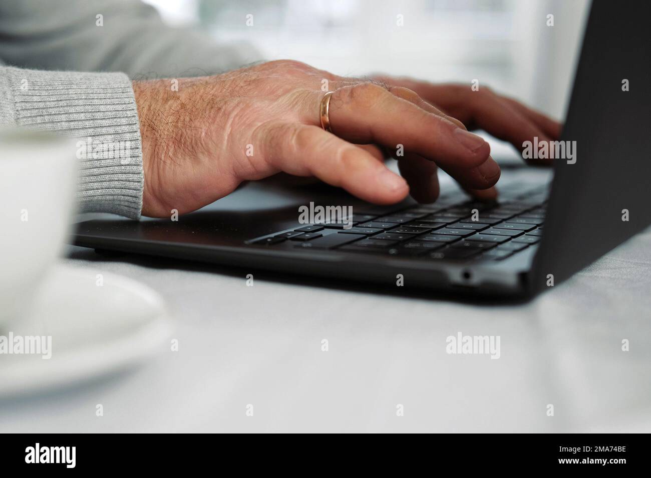 Closeup of senior man hands using laptop. Cropped side view of wrinkled ...