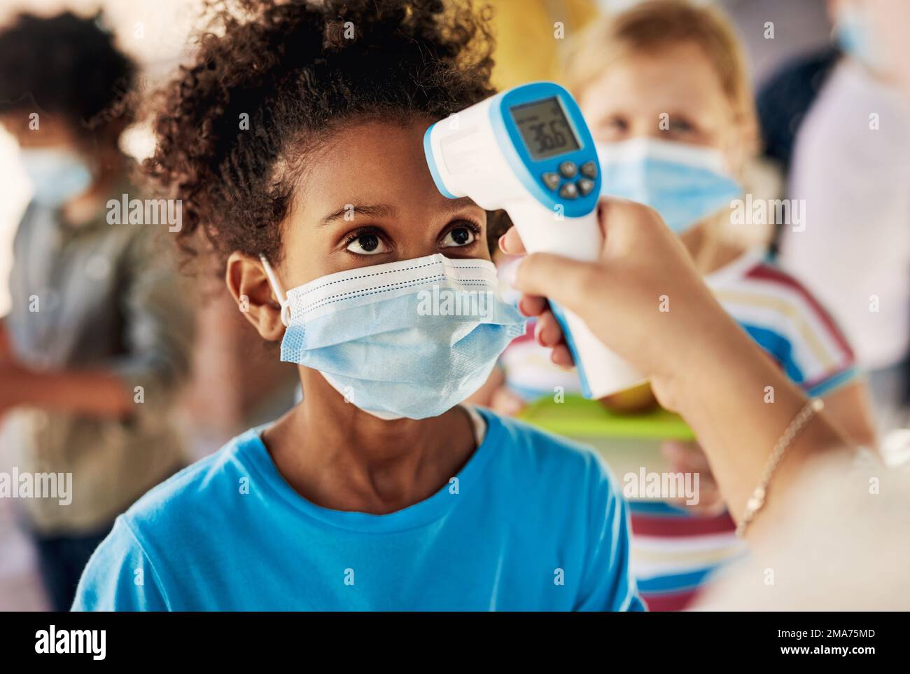 Your temperature is fine. a young girl wearing a mask and getting her ...