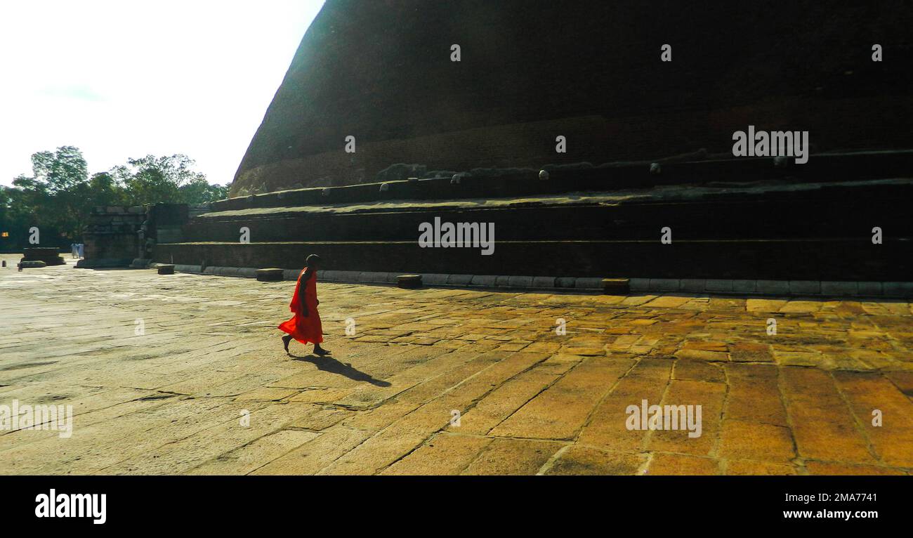 A samanera Bikku worships by walking around the stupa. The clockwise ...