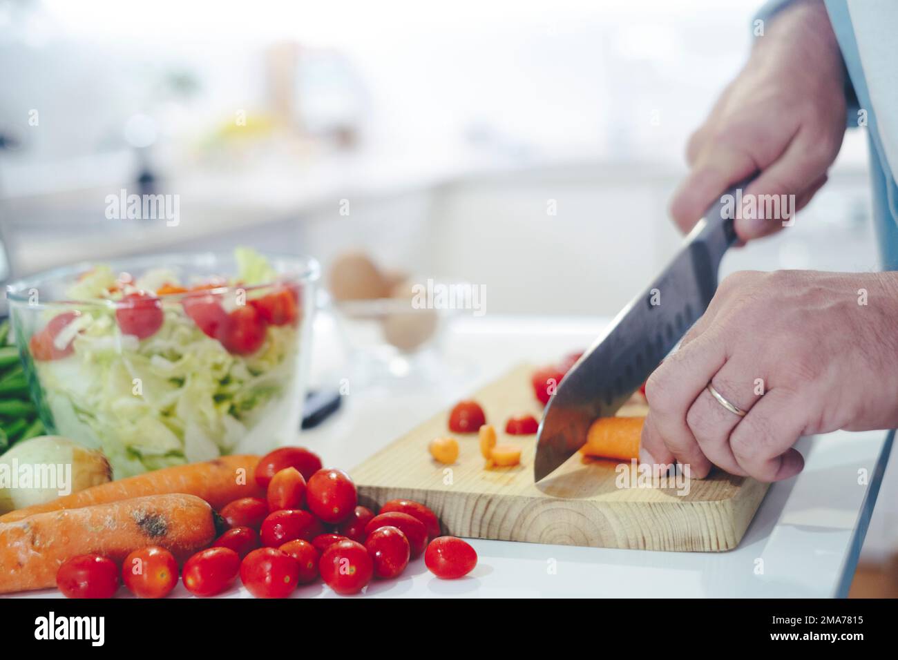 Chef at home using a knife cutting fresh raw vegetables. Cooker at home ...
