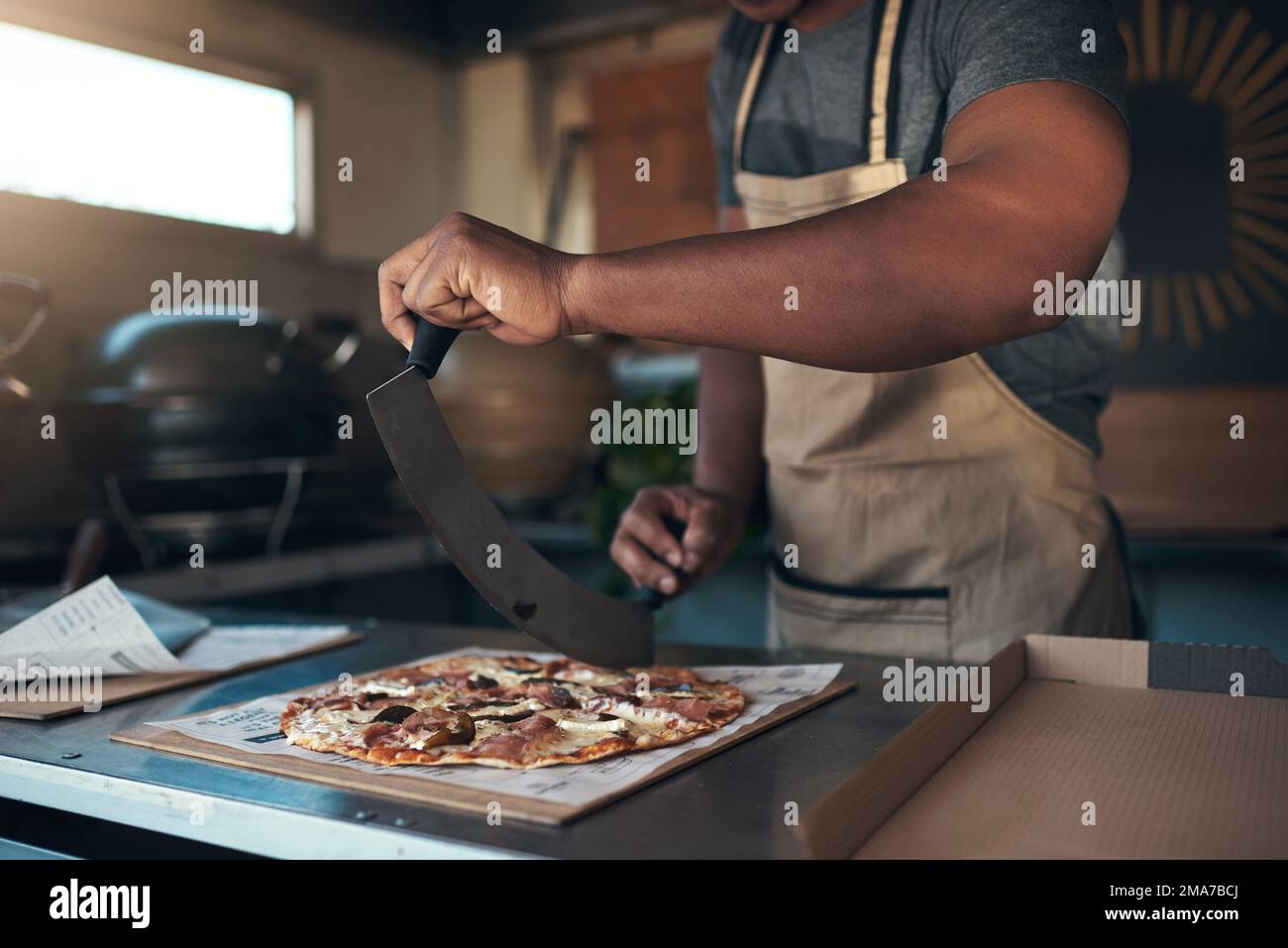 Every slice must be perfect. an unrecognizable man standing and ...