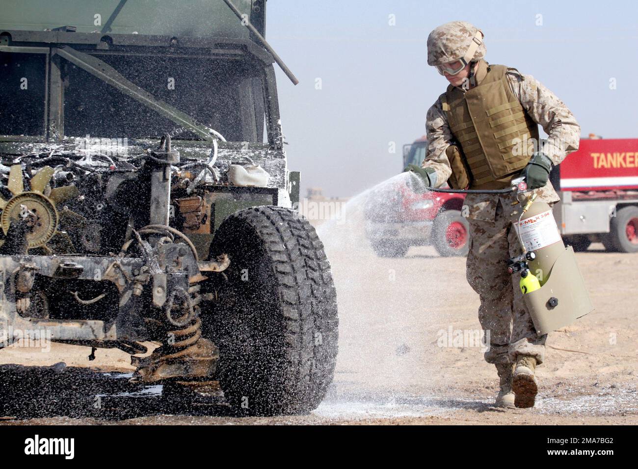 A US Marine Corps (USMC) Marine extinguishes a High-Mobility ...