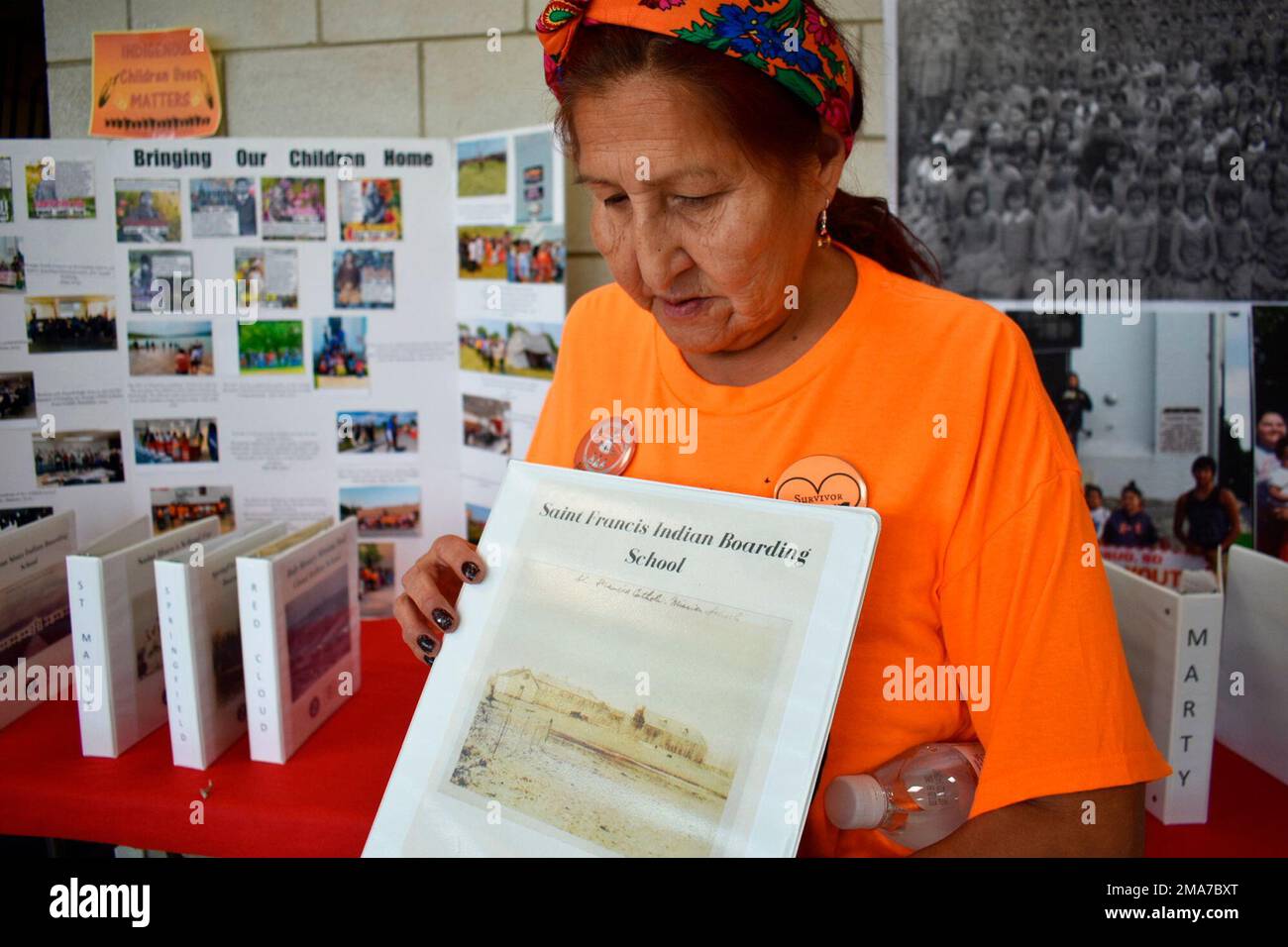 Ruby Left Hand Bull Sanchez holds a binder featuring a photo of the ...