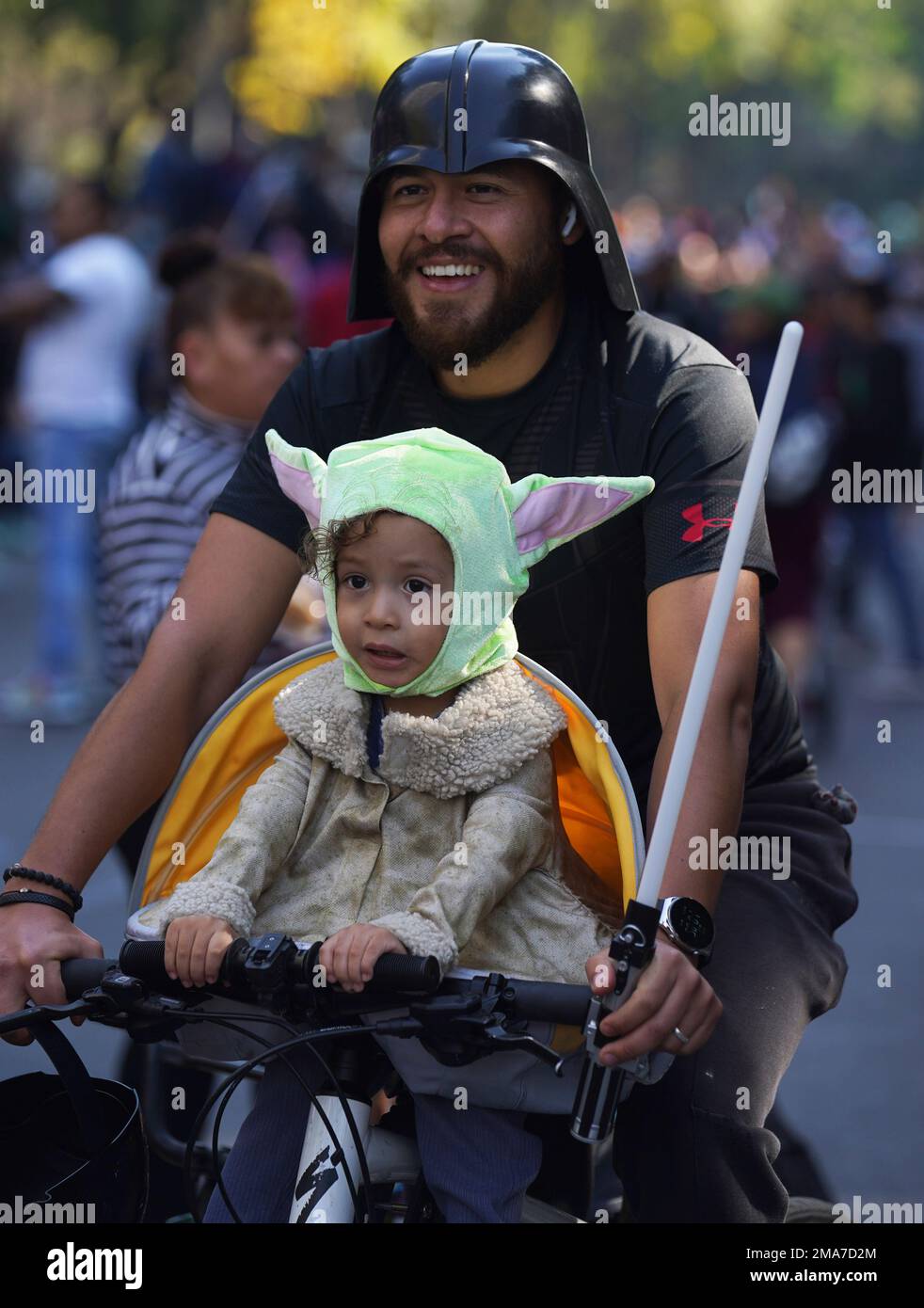 A father and daughter dressed as Star Wars characters ride a bicycle in ...