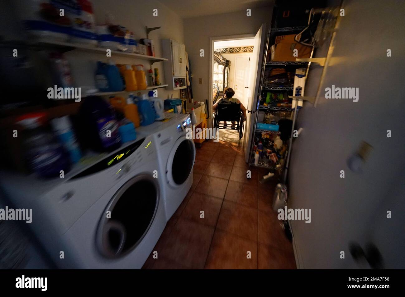 India Scott uses her wheelchair to get to her kitchen in her home in ...