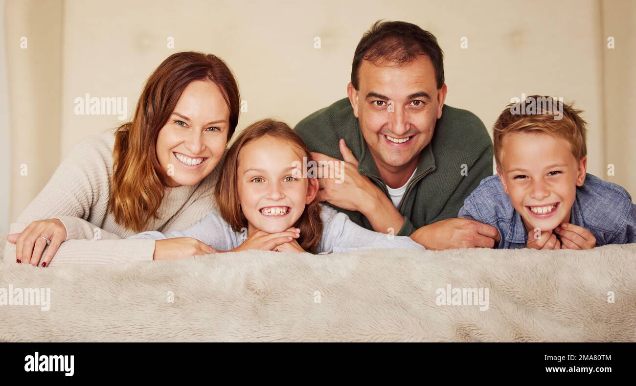 We look forward to the weekends together. a young family lying on the ...