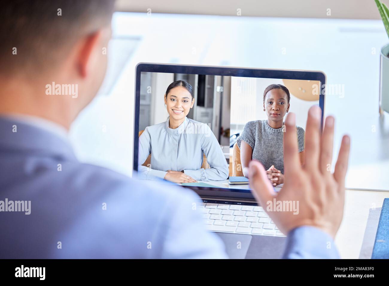 Hello, everyone. an unrecognizable businessman waving on a videocall at ...