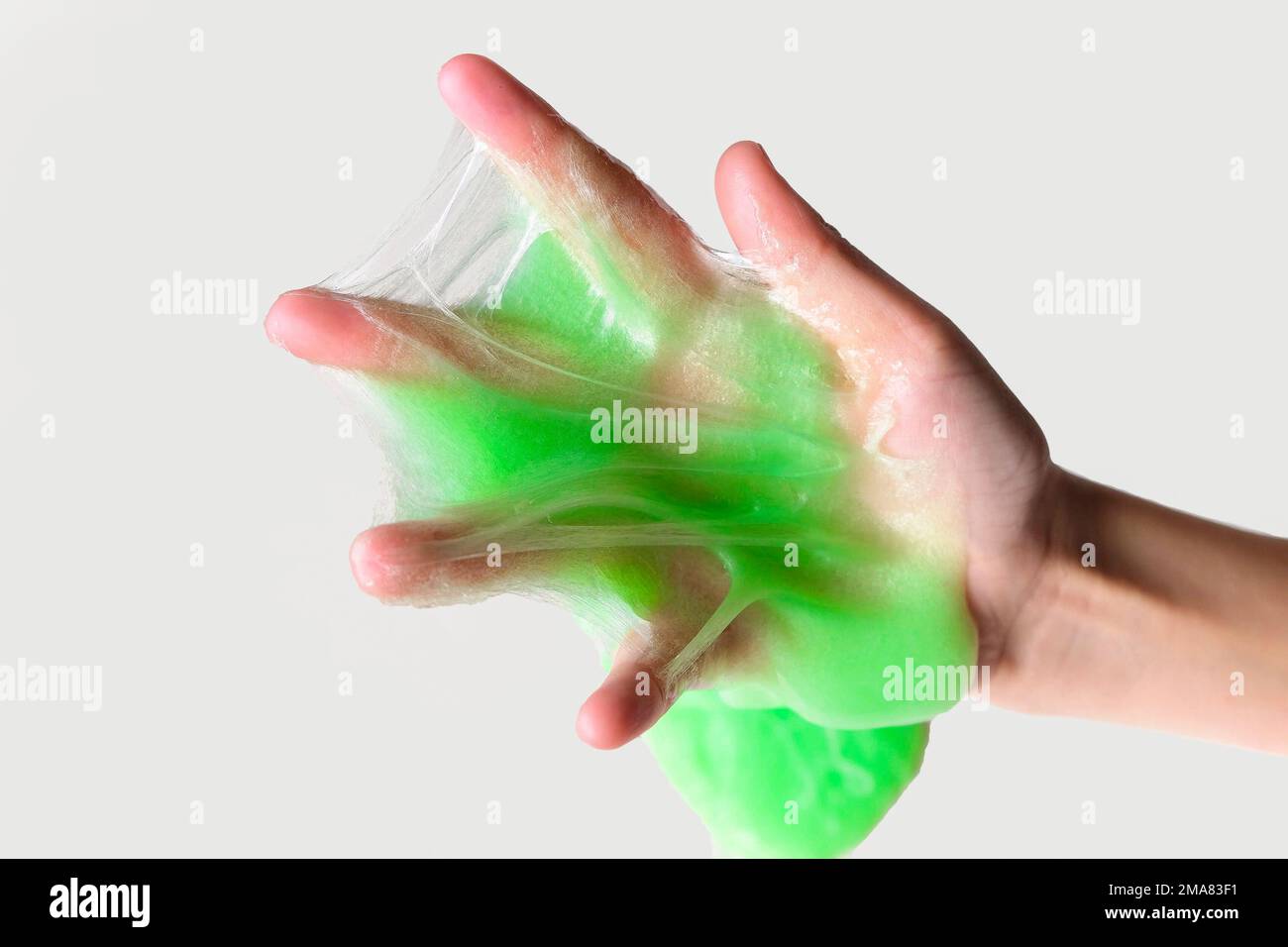 Hand Playing with textured slime on white background. Teen hand holding ...