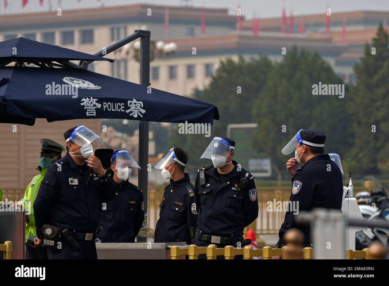 Police officers wearing face shields and masks chat each other as they ...