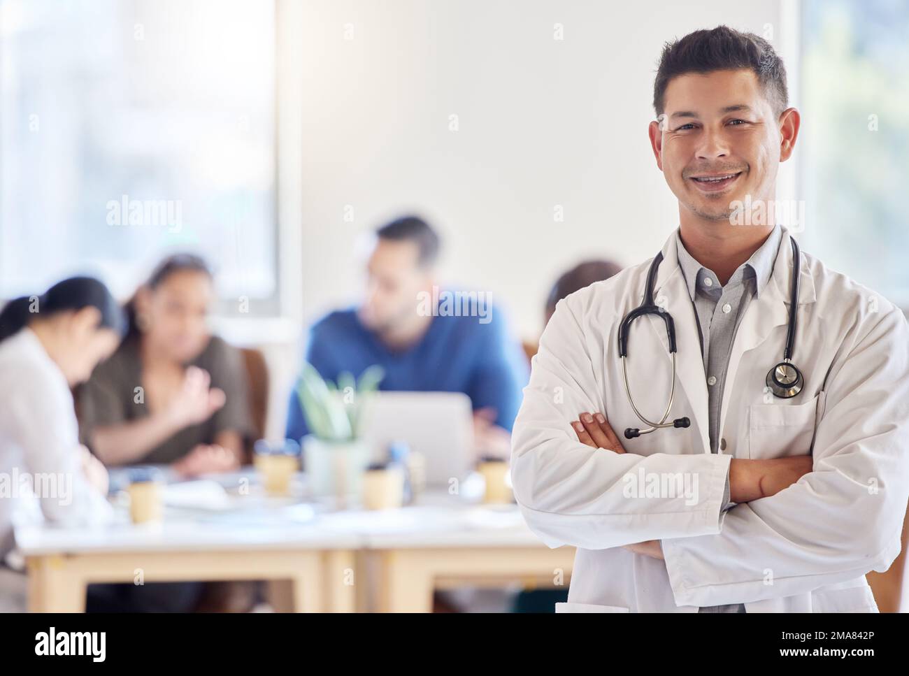 A doctor that likes to make a difference. a young male doctor standing ...
