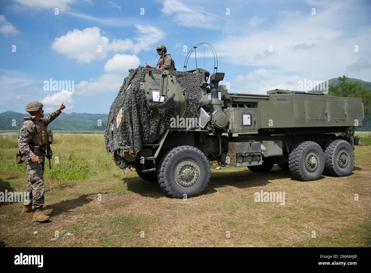 A U.S. Marine signals to another on a High Mobility Artillery Rocket ...