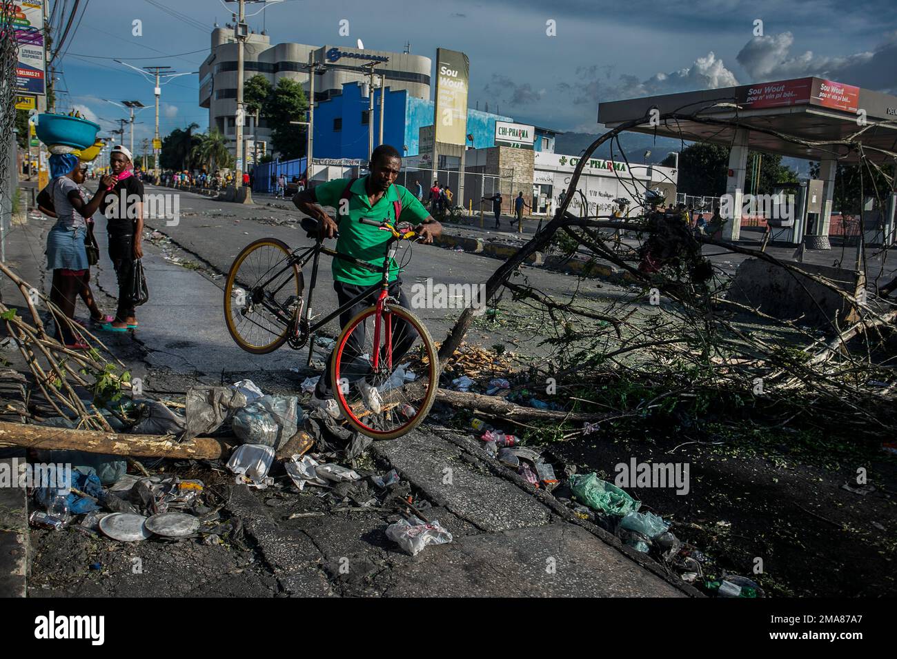 A man carries a bicycle while crossing a barricade in Port-au-Prince ...