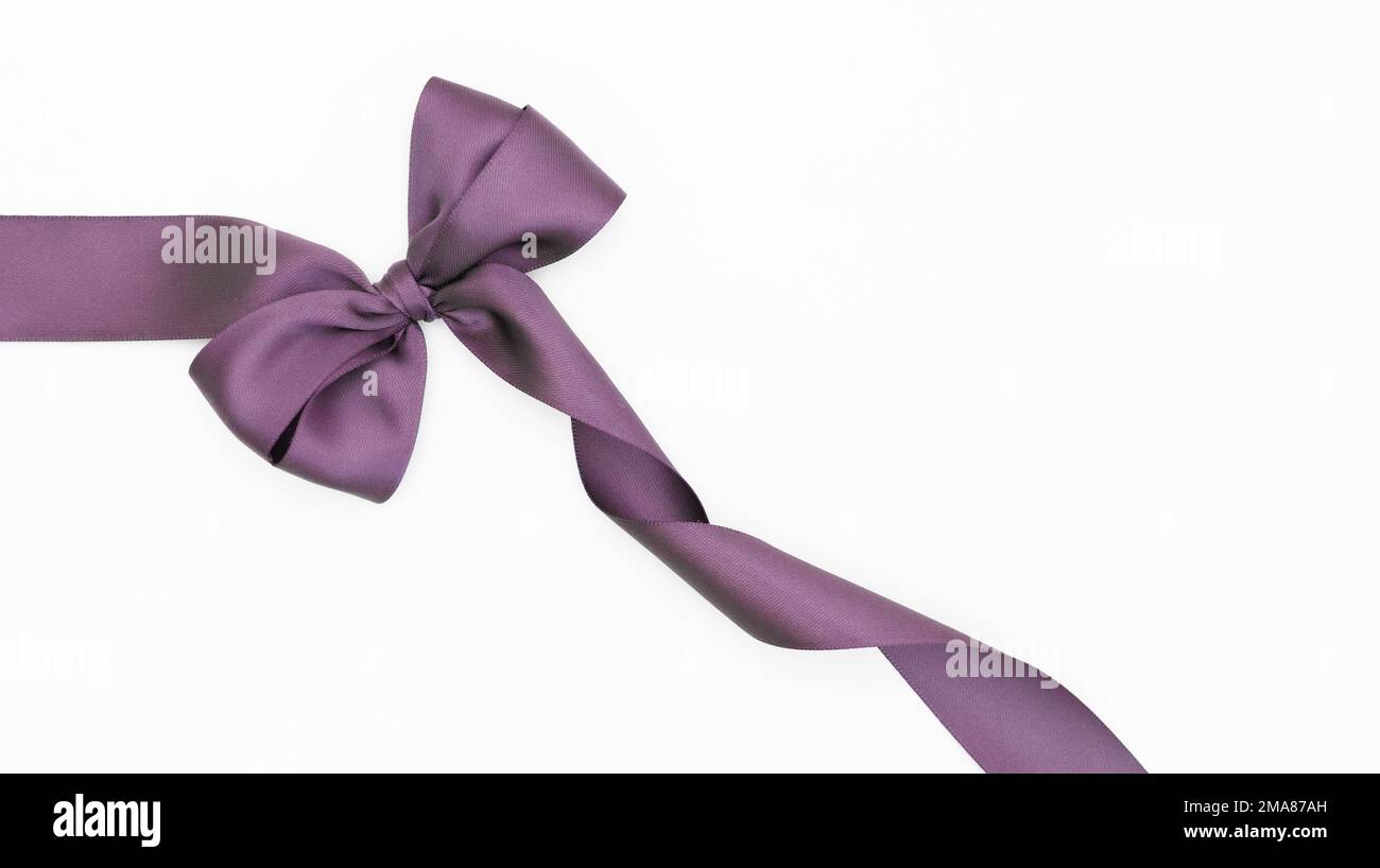 Satin ribbon bow for gift pack in purple color, isolated on white ...