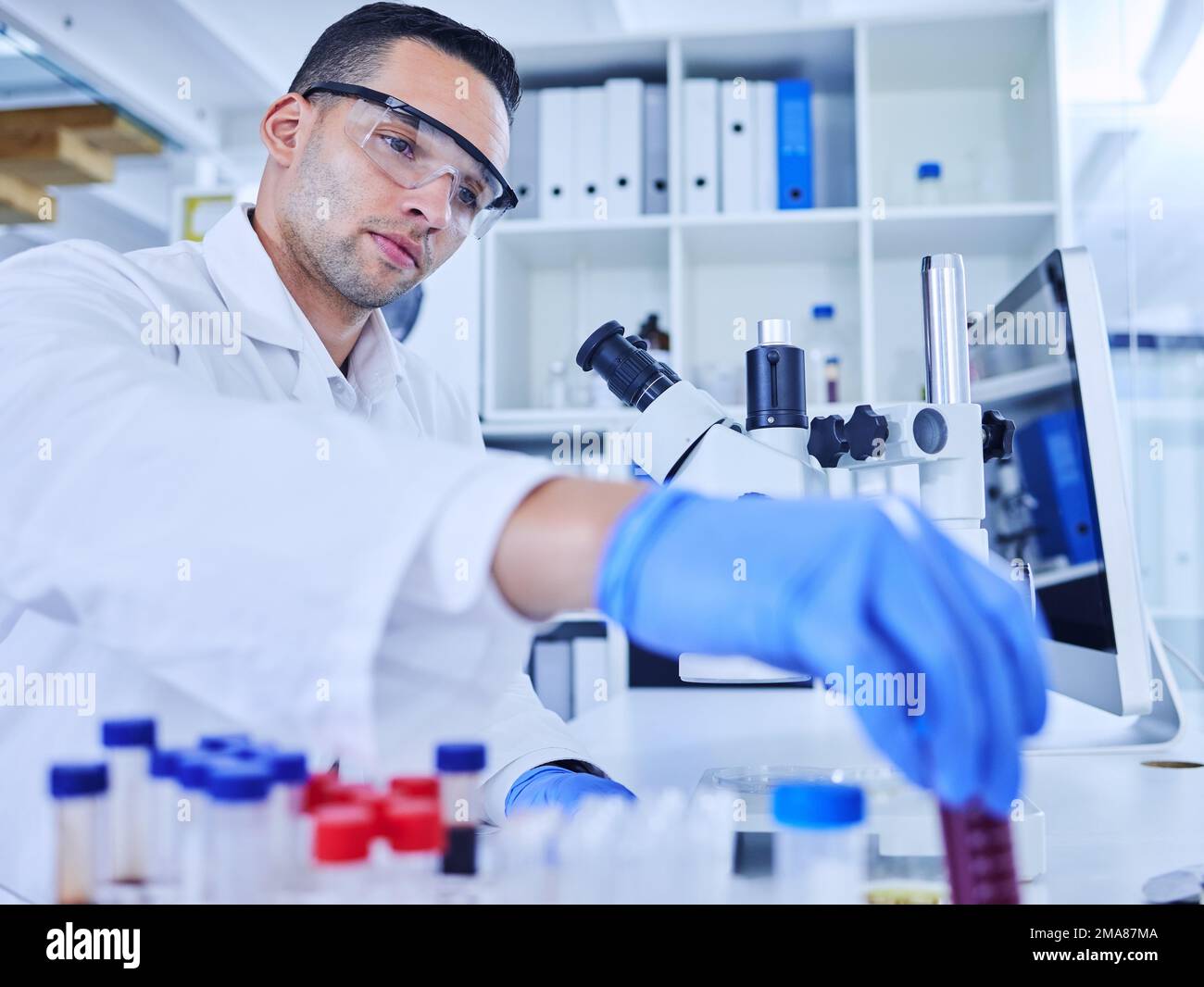 Another one ready for testing. a handsome young male scientist working ...