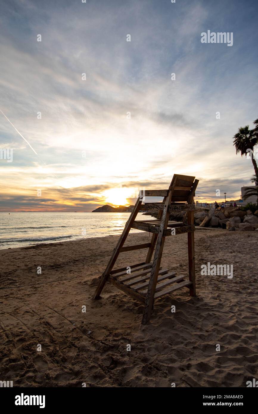 A vertical shot of a lifeguard chair on a beach at sunset in Benidorm ...
