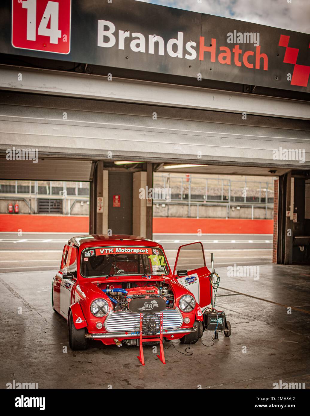 Classic red mini owned by VTK Motorsport being serviced in the pit ...