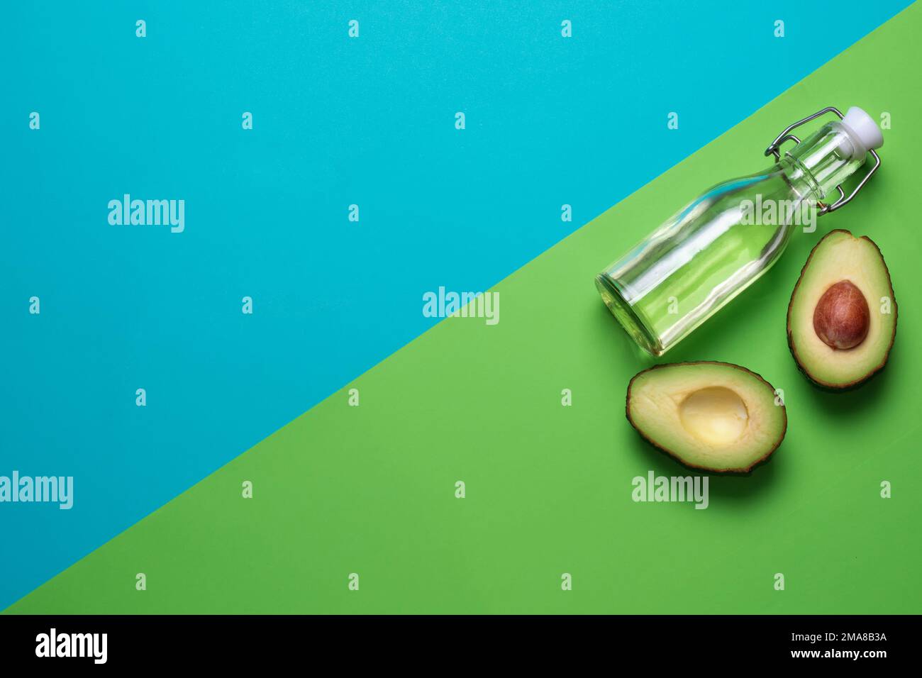 Fresh avocados on a blue and green background. Avocado oil in a bottle ...
