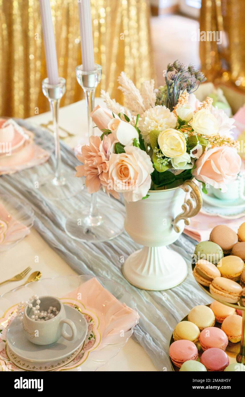 A vertical top view of a dessert table with beautiful tea time utensils ...