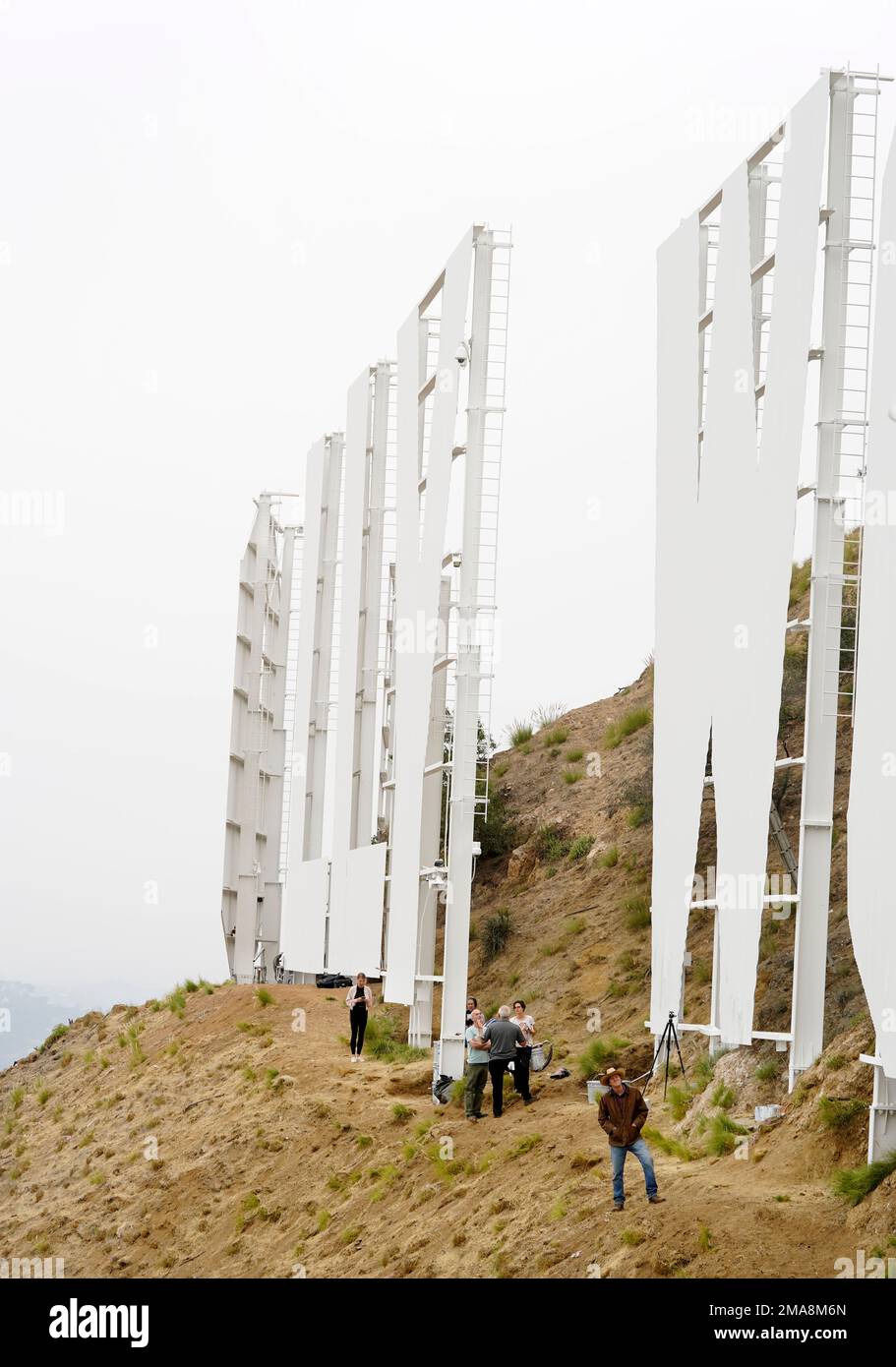 Onlookers watch crews clean the Hollywood sign to ready it for a fresh ...