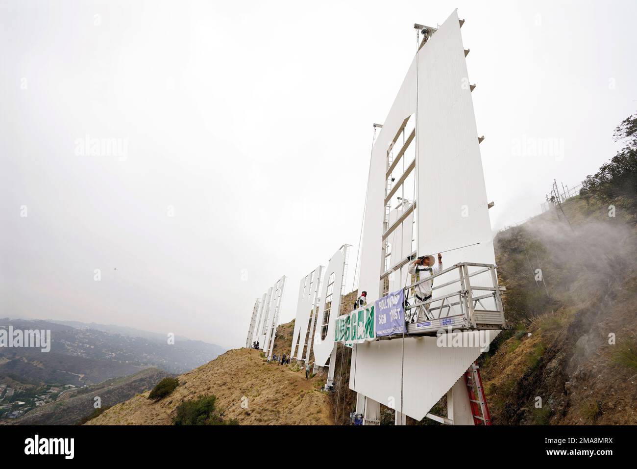 Ruben Palalla of Duggan Construction, right, cleans grime off the "D ...