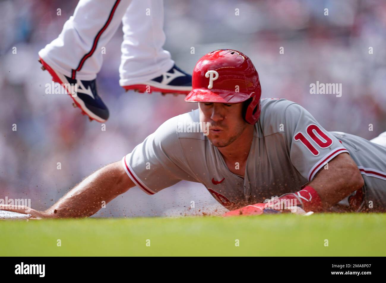 Philadelphia Phillies catcher J.T. Realmuto (10) slides back safely ...