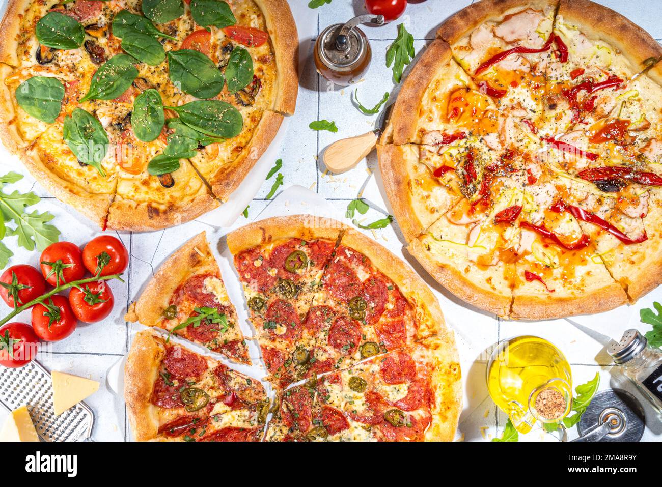 Three various pizzas, served at home or in restaurant on tiled table ...