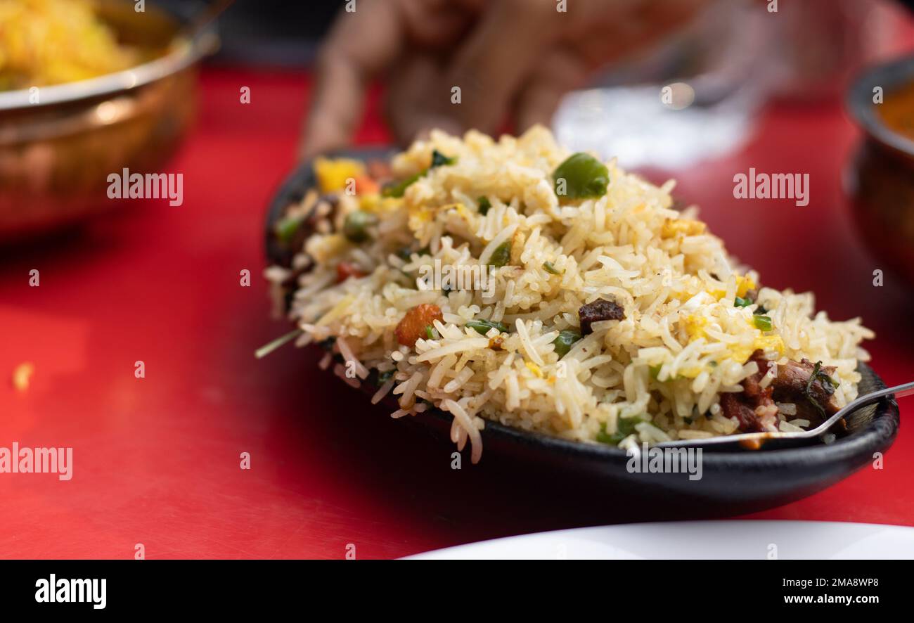 A plate of mixed fried rice - a chinese Indian food served on red table ...