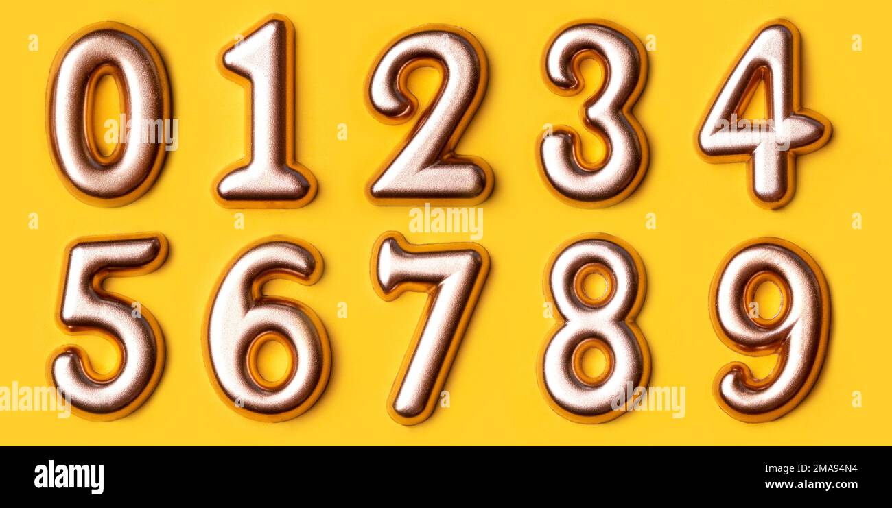 Metal numbers set on a yellow background Stock Photo - Alamy