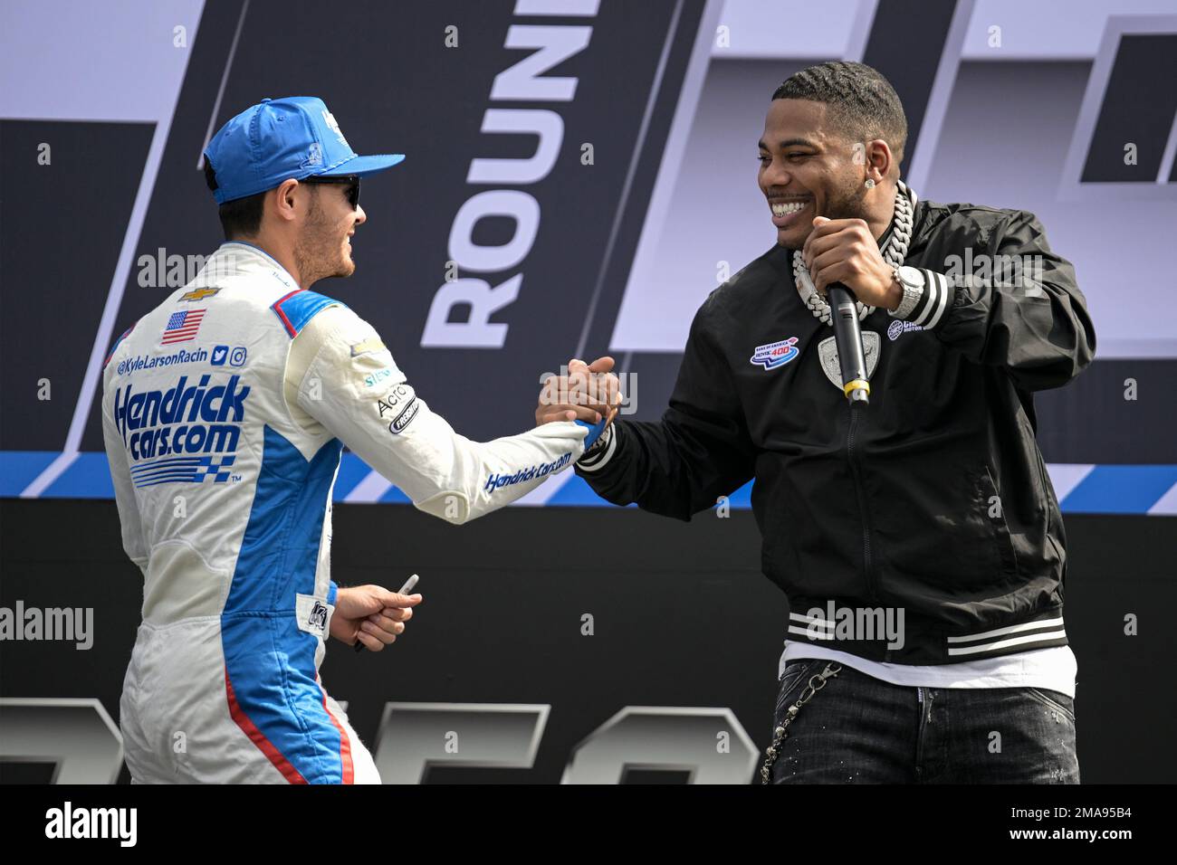 Rapper Nelly, right, and Kyle Larson, left, embrace prior to a NASCAR ...