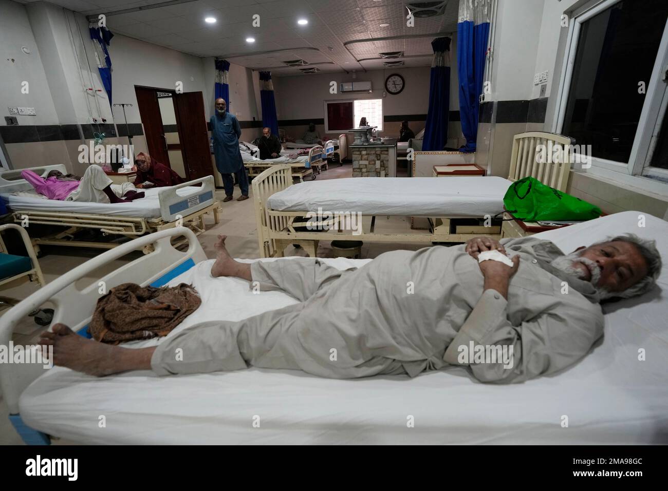 Men lie on beds in the cardiac ward of a hospital in Karachi, Pakistan ...