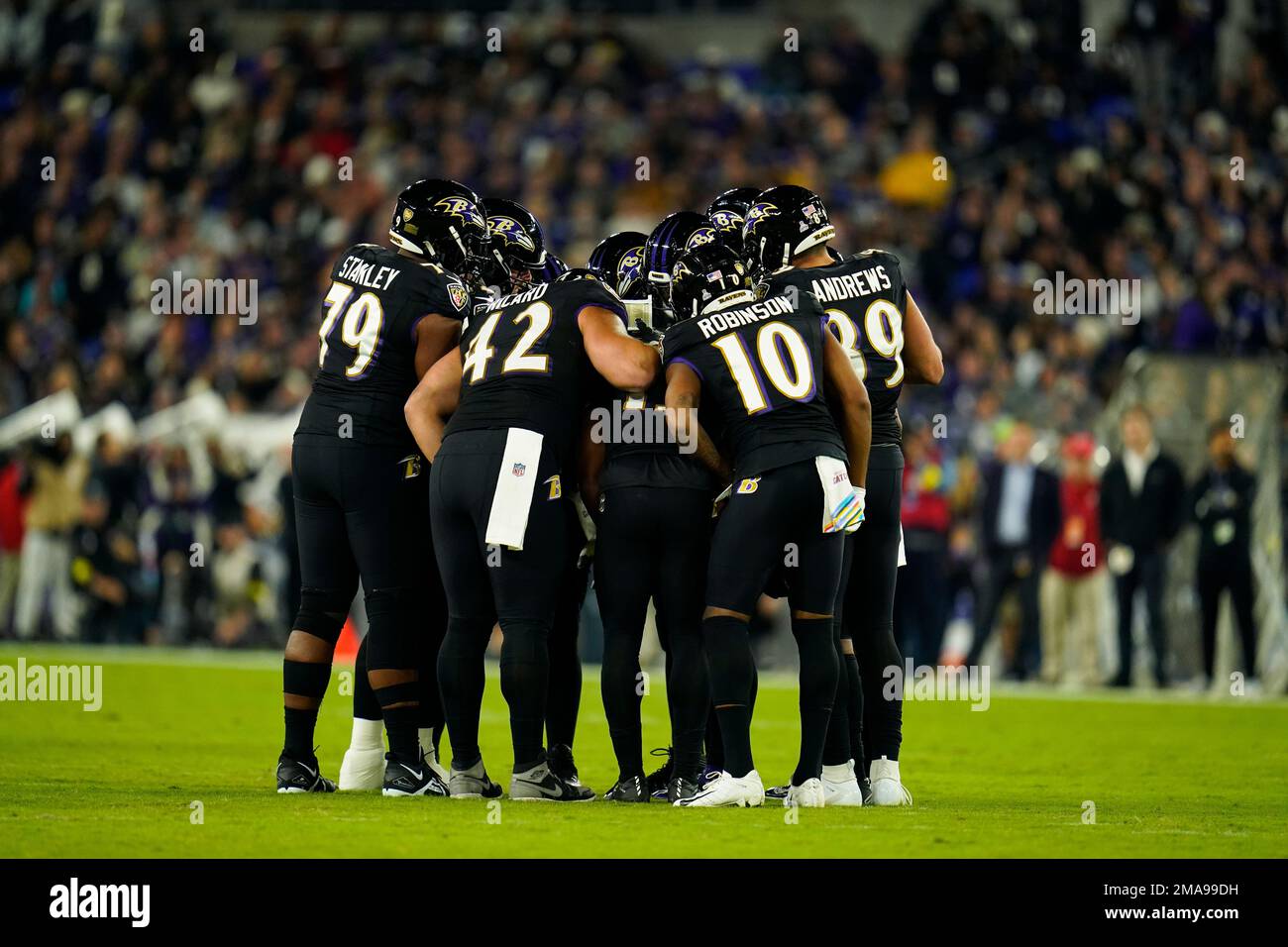 Baltimore Ravens players huddle during the first half of an NFL ...