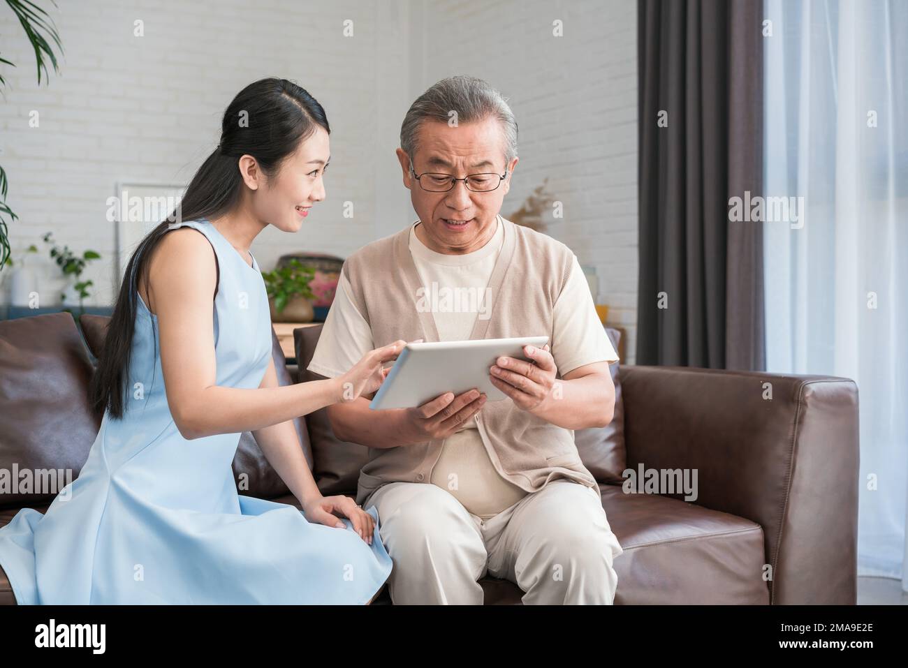 Father and daughter two people use tablet computers Stock Photo - Alamy