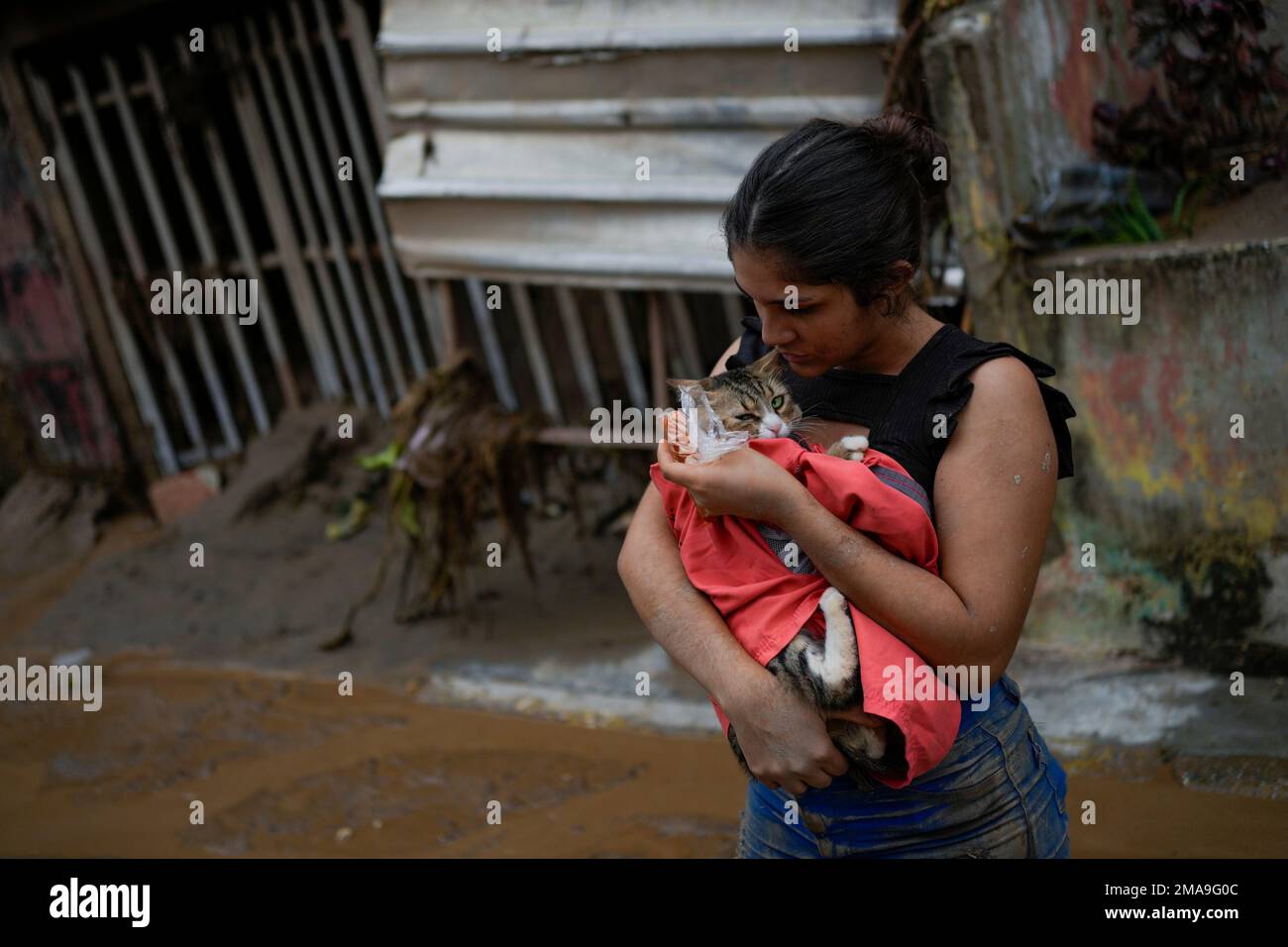 Karen Salinas holds her cat next to her home damaged by flooding in Las ...