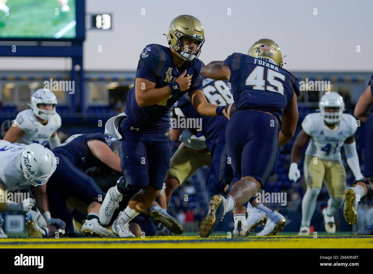 Navy quarterback Tai Lavatai, center, hands off to fullback Daba Fofana ...