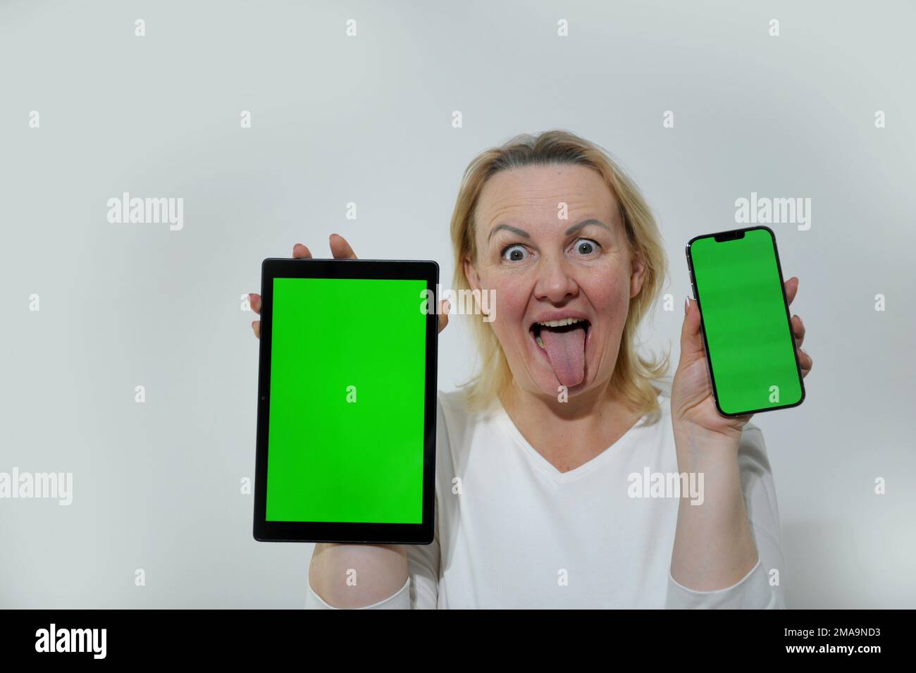adult woman with two gadgets on a white background screen green ...