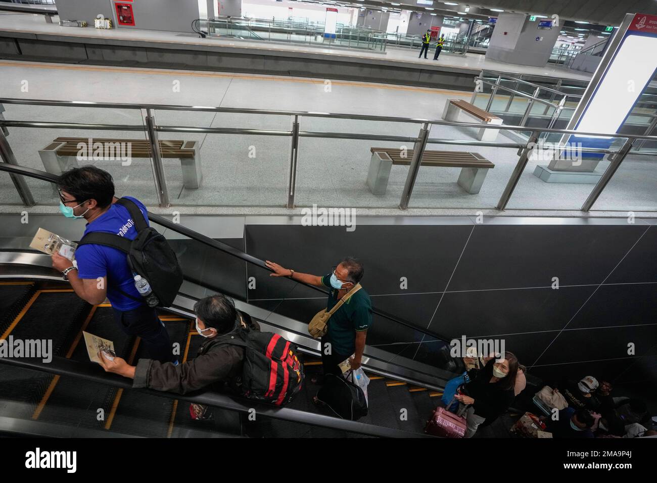 Passengers ride an escalator to the platform top board an outbound ...