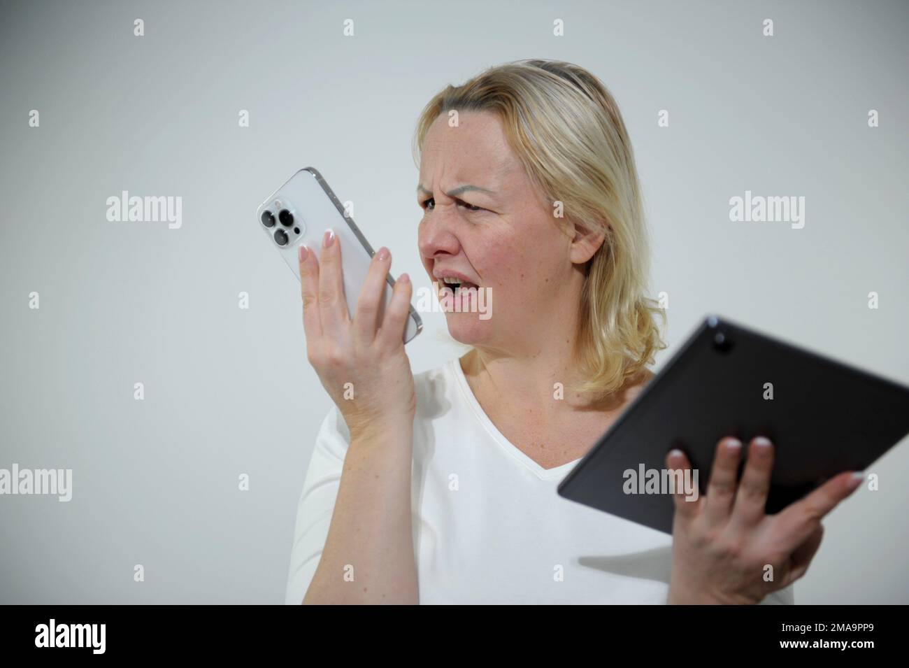 Angry woman talking on phone, looking at laptop screen, irritated woman ...