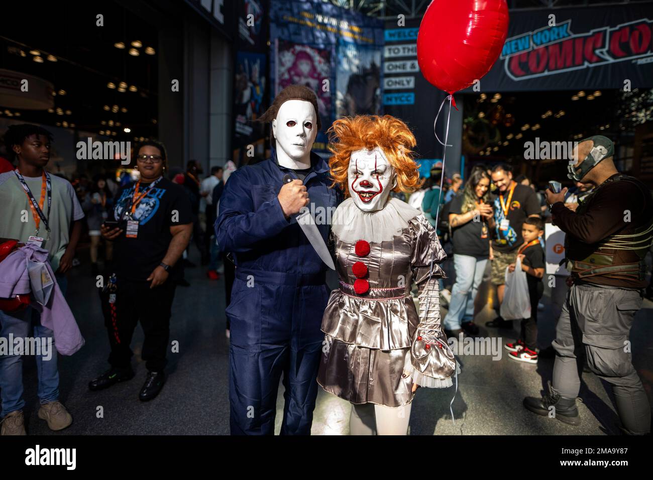 Attendees dressed as Michael Meyers, left, and Pennywise pose during ...