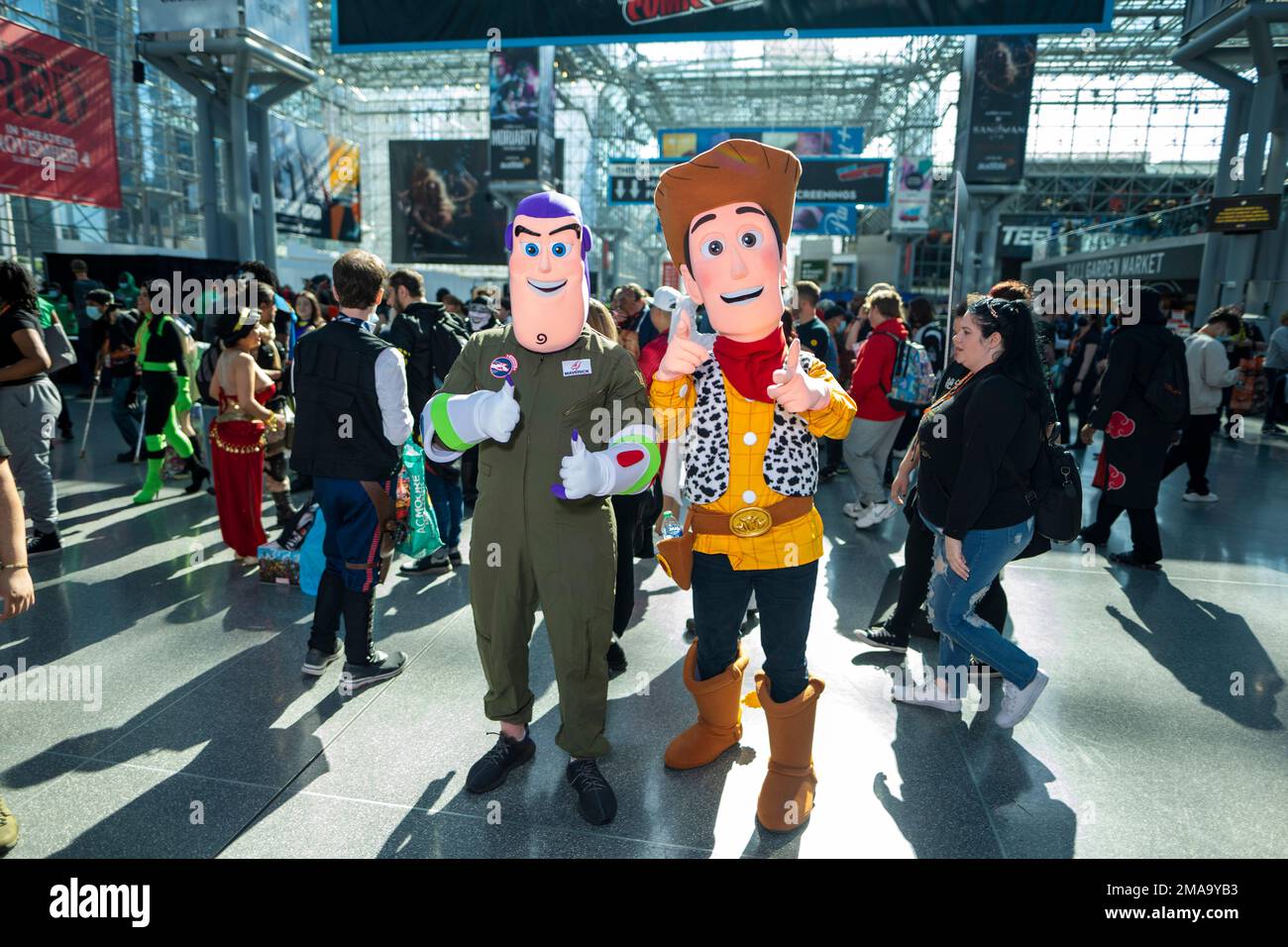Attendees dressed as Buzz Lightyear, left, and Sheriff Woody from "Toy Story" pose during New ...