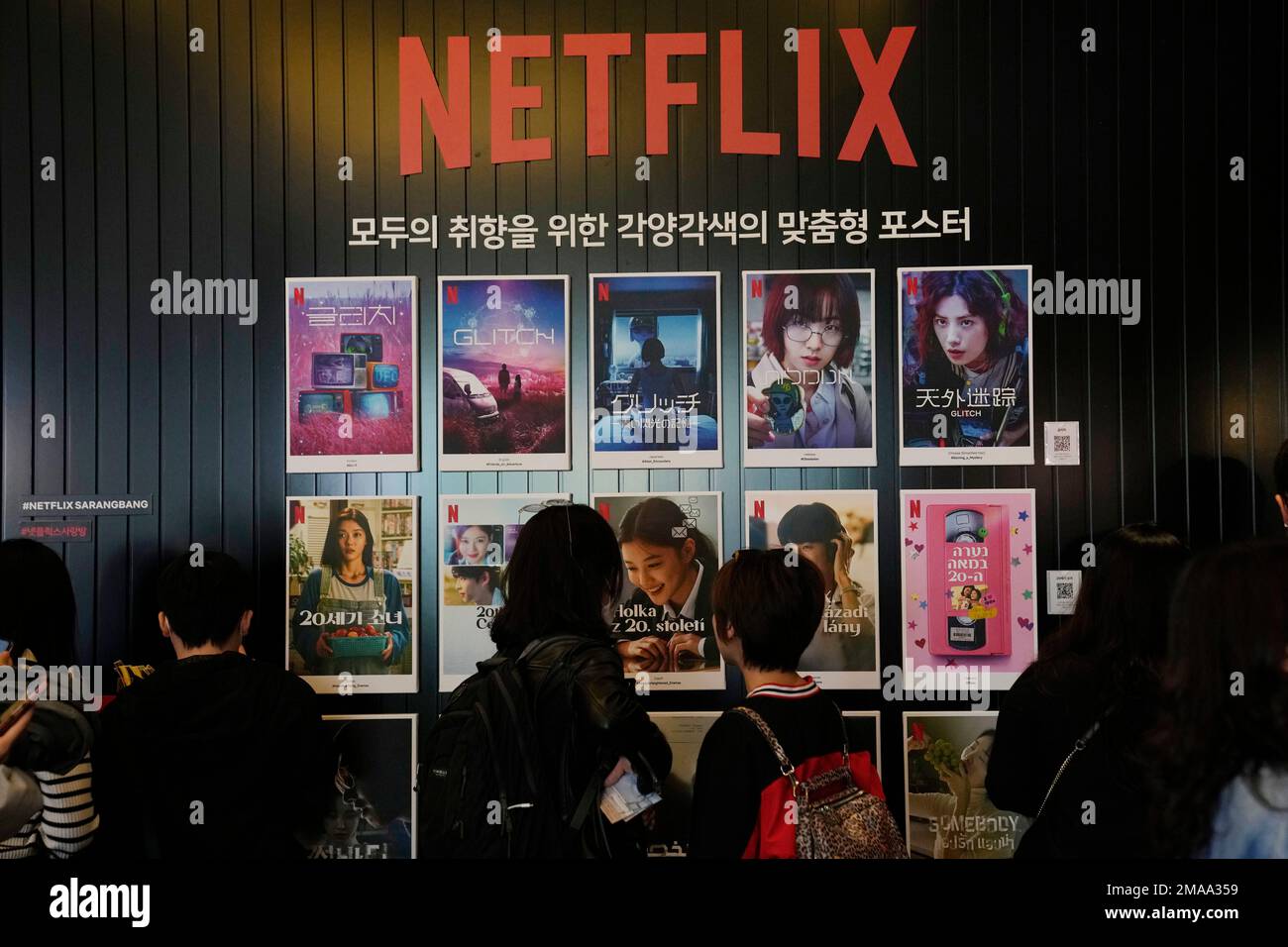 Visitors watch 2022 Netflix Korea series and film posters during the 27th Busan International ...