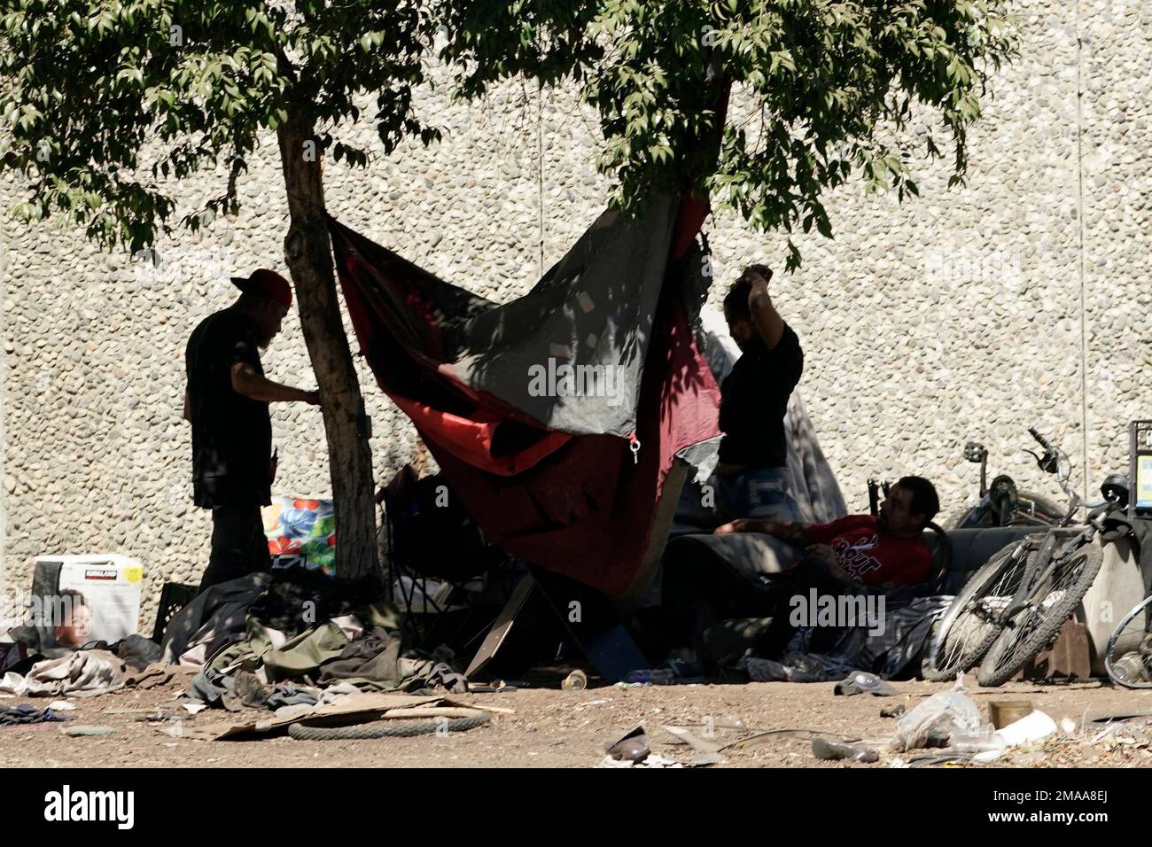 A homeless encampment is shaded by a tree in Sacramento, Calif., Friday ...