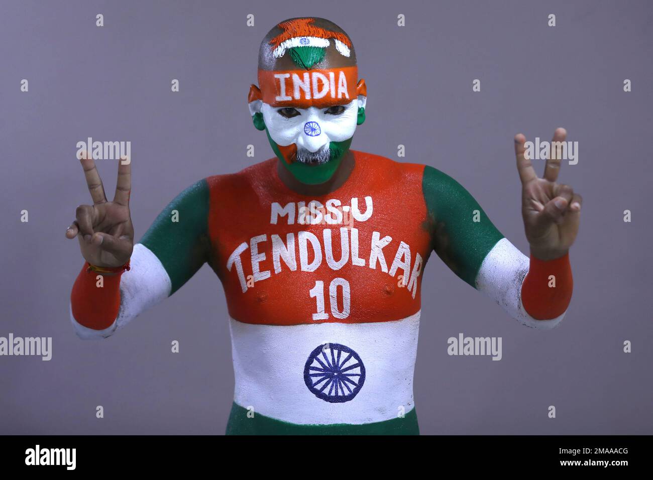 A fan of former Indian cricketer Sachin Tendulkar with his boy painted ...