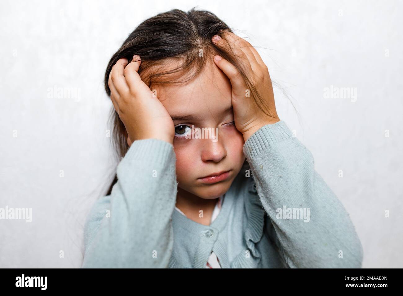 sad girl sitting on a light background Stock Photo - Alamy