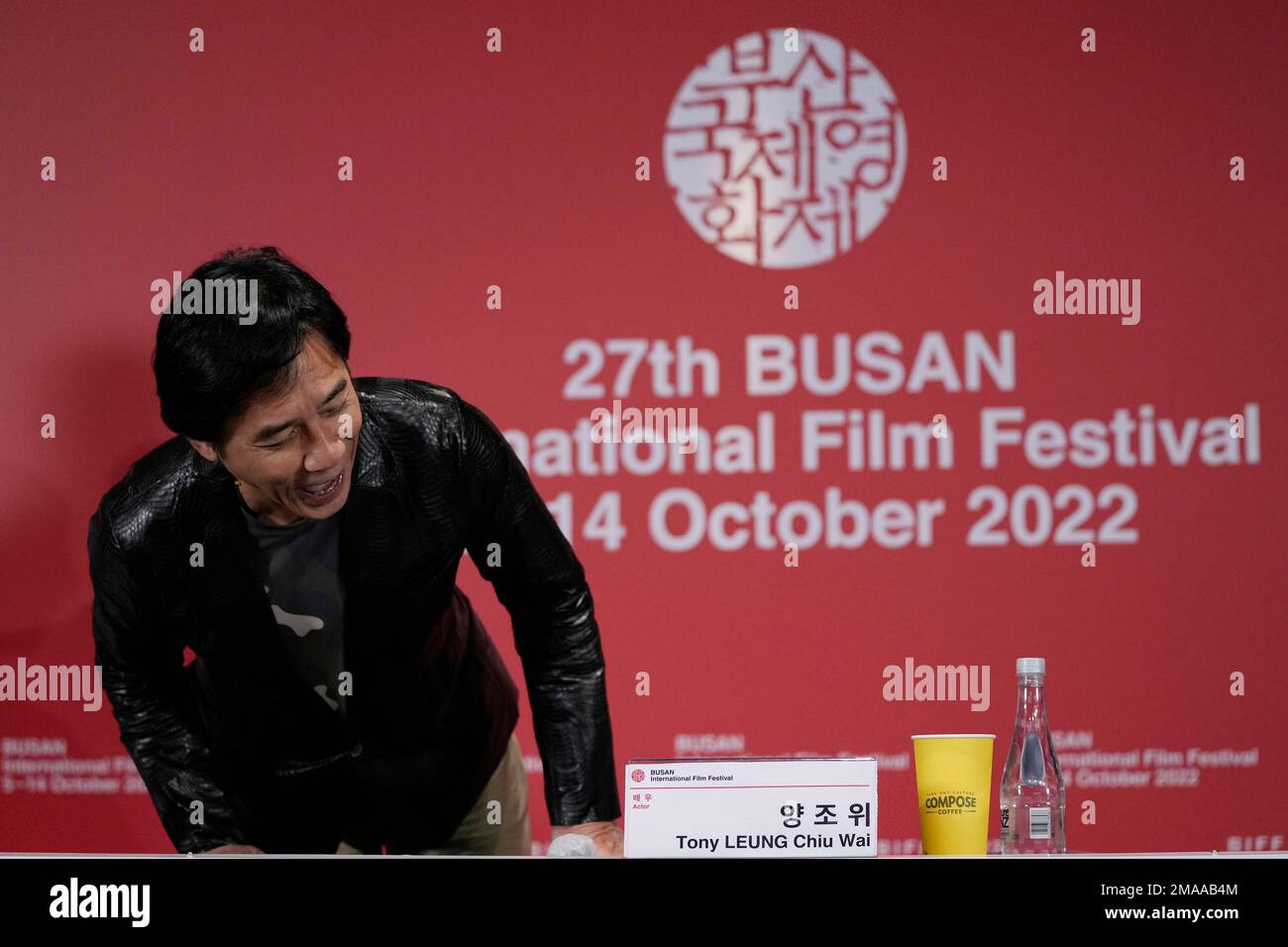 Hong Kong actor Tony Leung watches his nameplate during his press conference at the 27th Busan ...