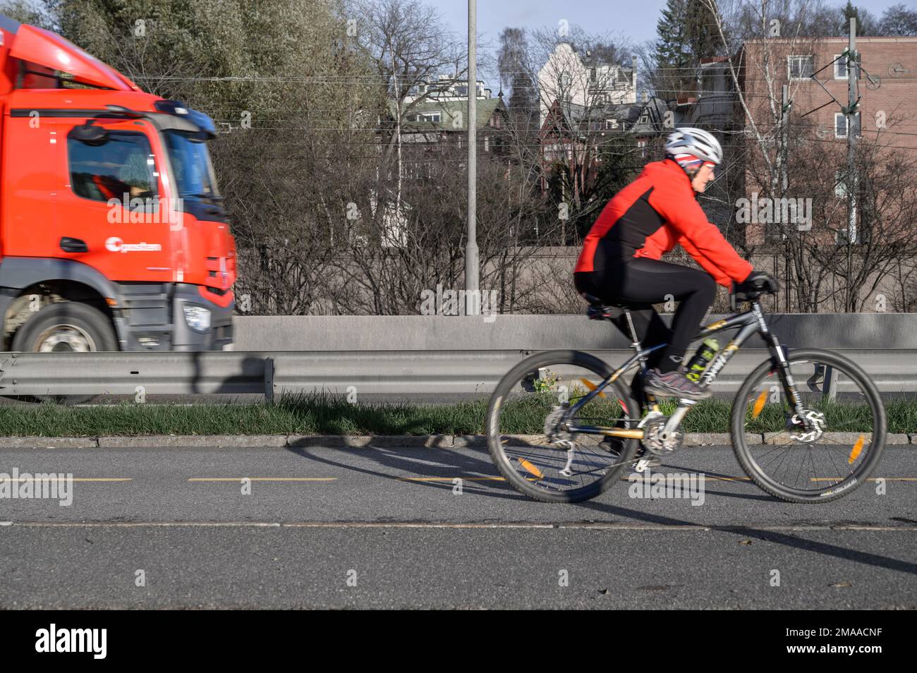 Cyclist cycling in a dedicated cycle lane separated from the motorway ...
