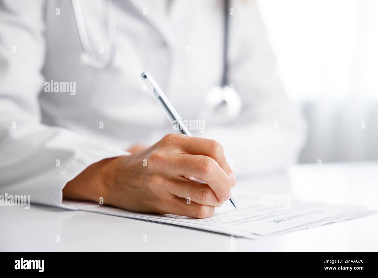 Woman medic, doctor writes out a prescription. Makes an entry in the ...