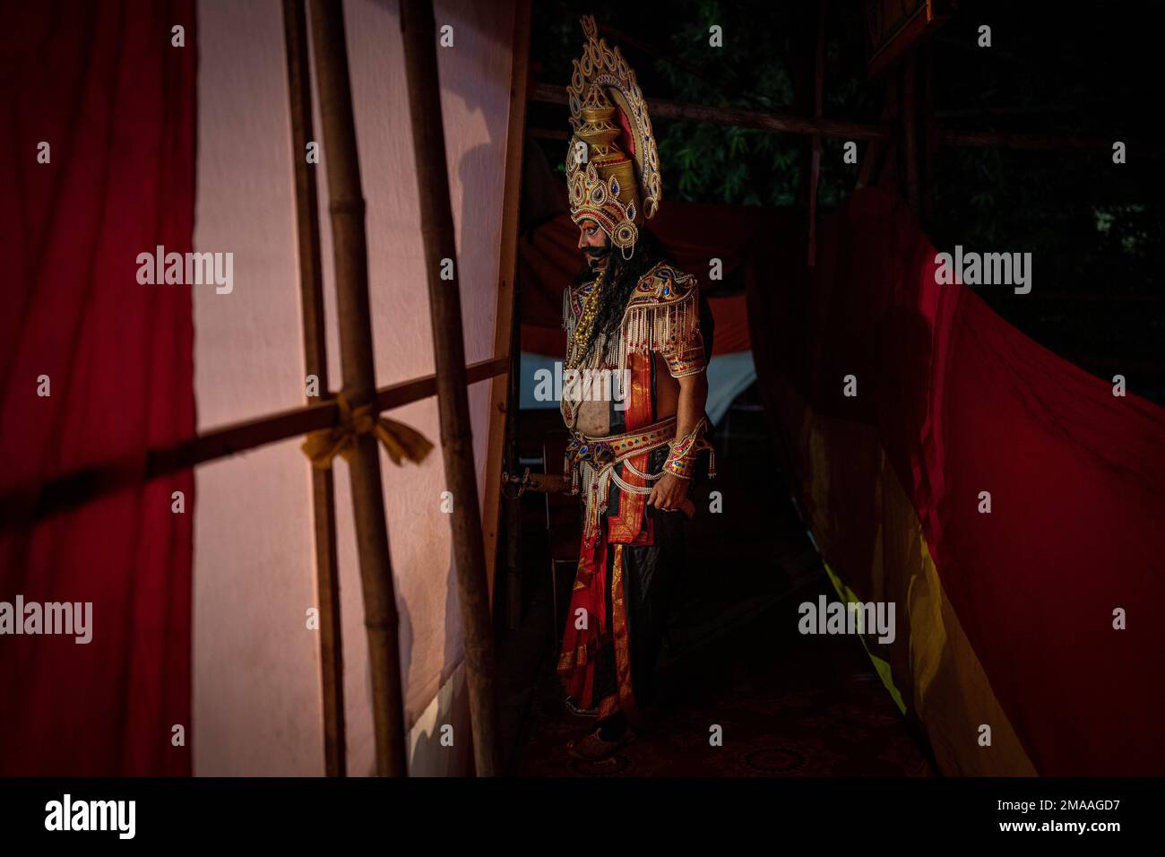 An artist dressed as demon king Ravana waits backstage for his entry on ...