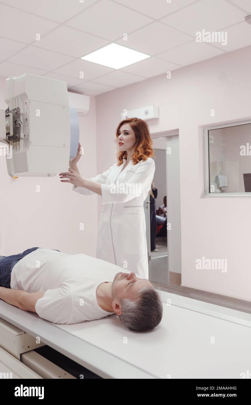 a female radiologist technician sets up a rengen device to conduct a ...