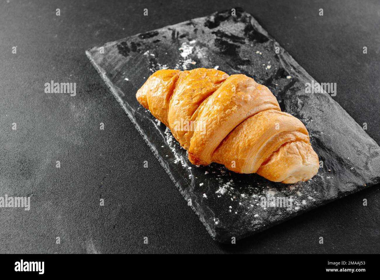 Large croissant on black background. Fresh and delicious French ...
