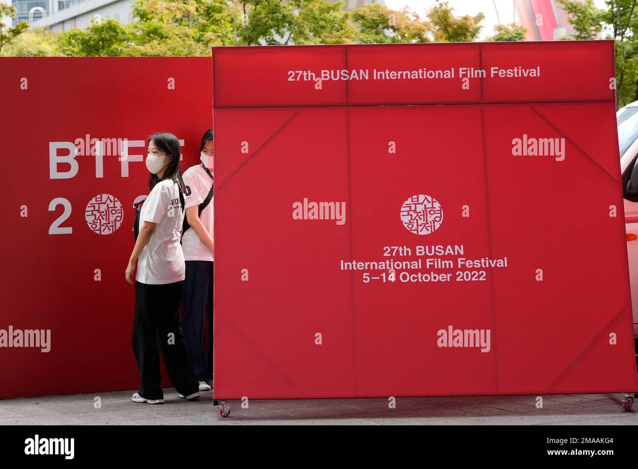Volunteers stand in front of banners during the 27th Busan International Film Festival (BIFF) at ...